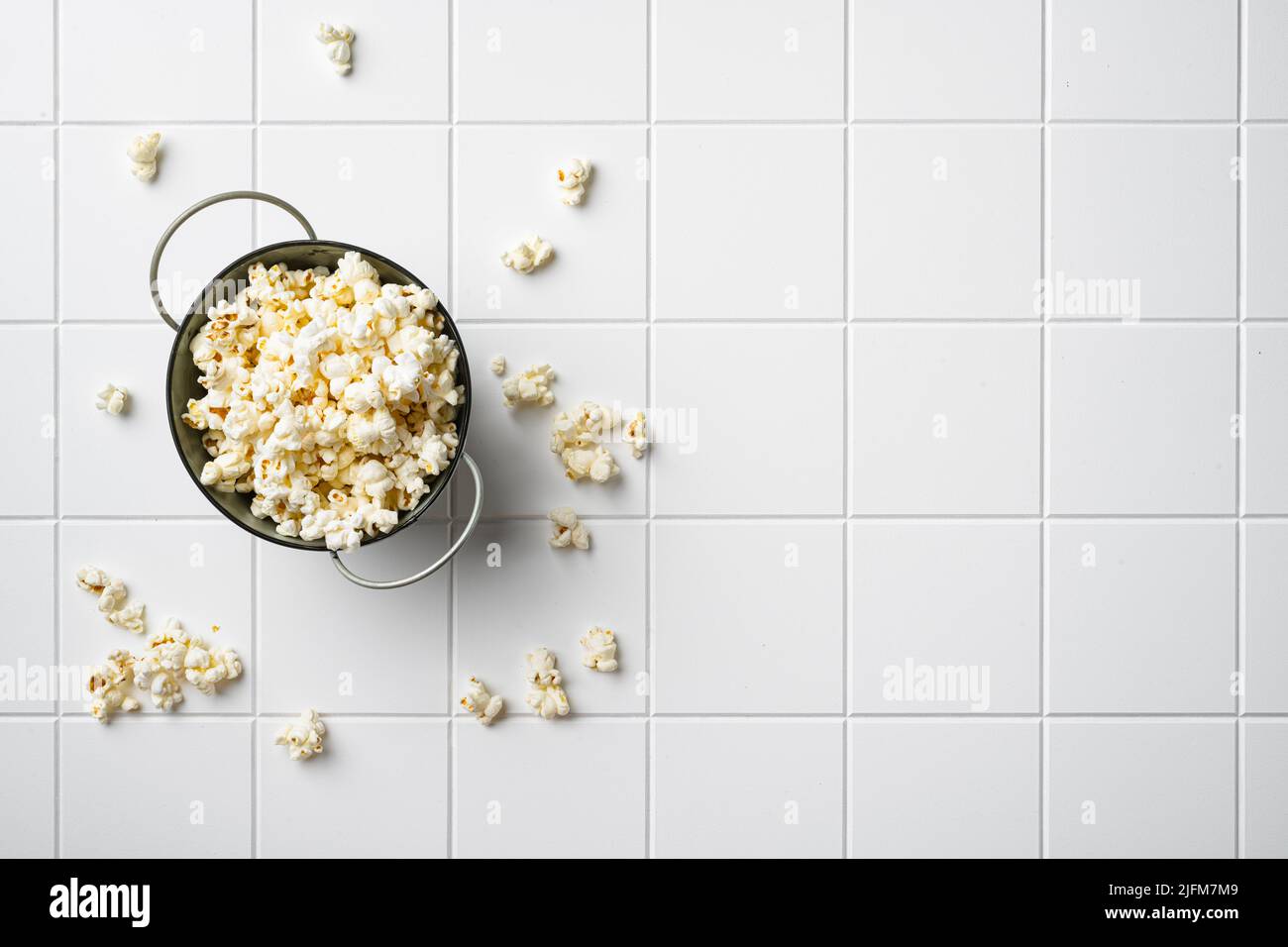 Heap of delicious popcorn on white ceramic squared tile table ...
