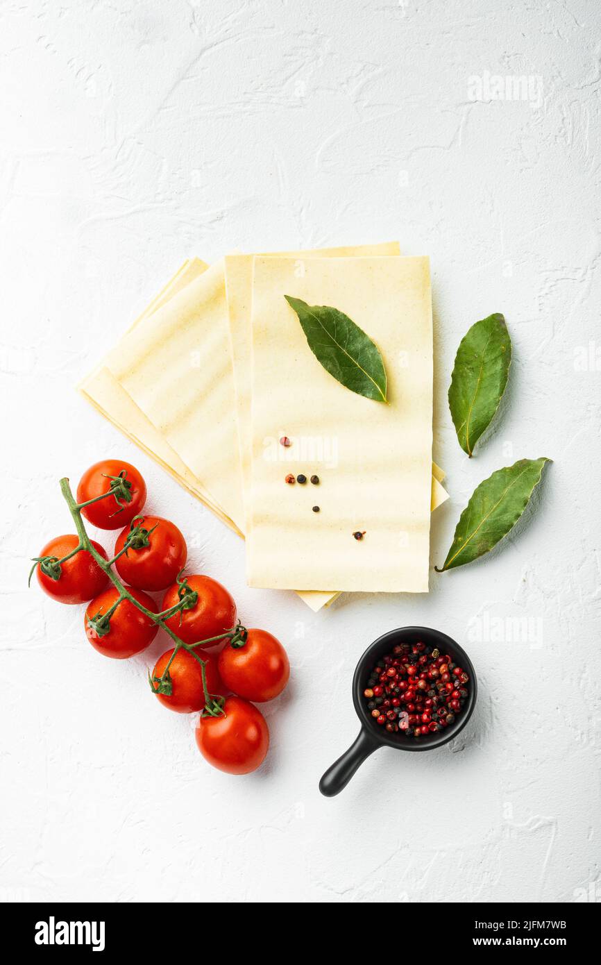 Dried uncooked lasagna pasta sheets, with seasoning and herb, on white ...