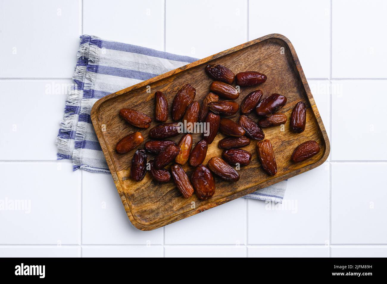 Traditional arabic dry dates set, on white ceramic squared tile table ...