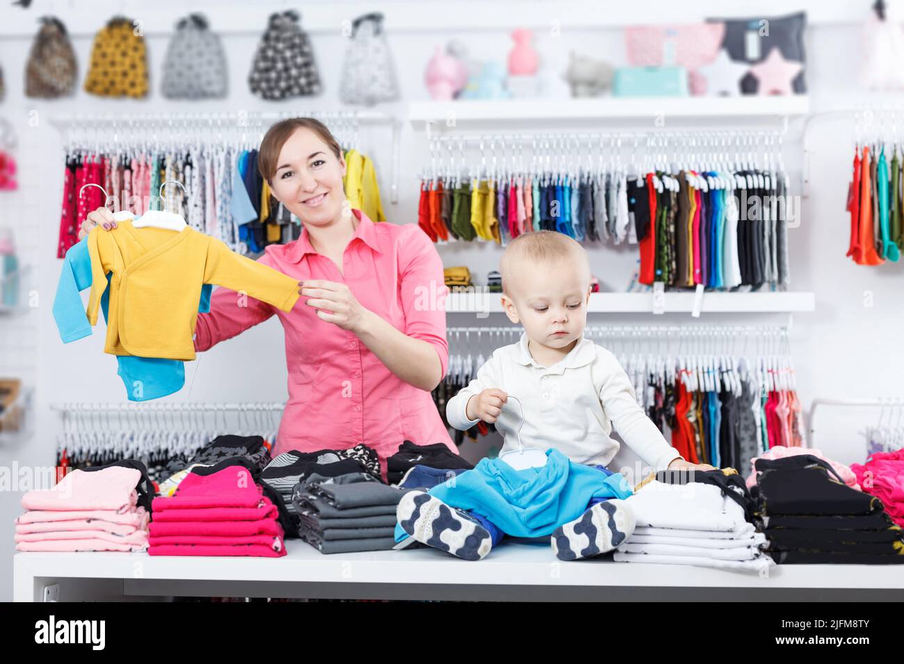 kid who is posing when his mother choosing clothes Stock Photo - Alamy