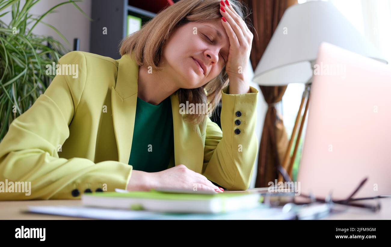 Tired businesslady putting hand to forehead and closed eyes Stock Photo ...