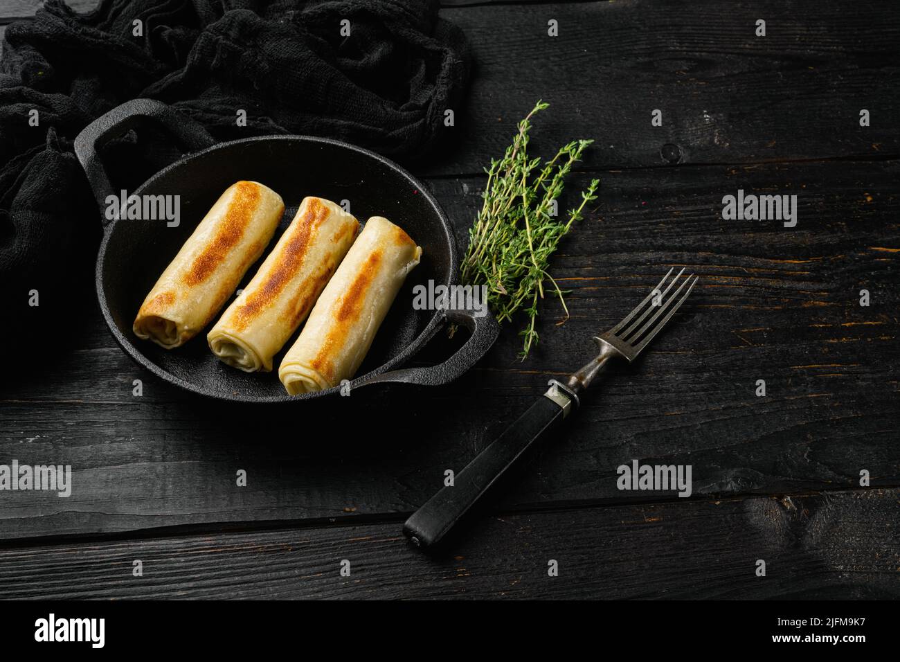Georgian crepes stuffed on black wooden table background, with copy ...