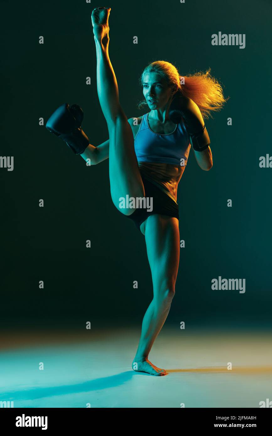 One young woman, female professional kickboxer in sports uniform and ...