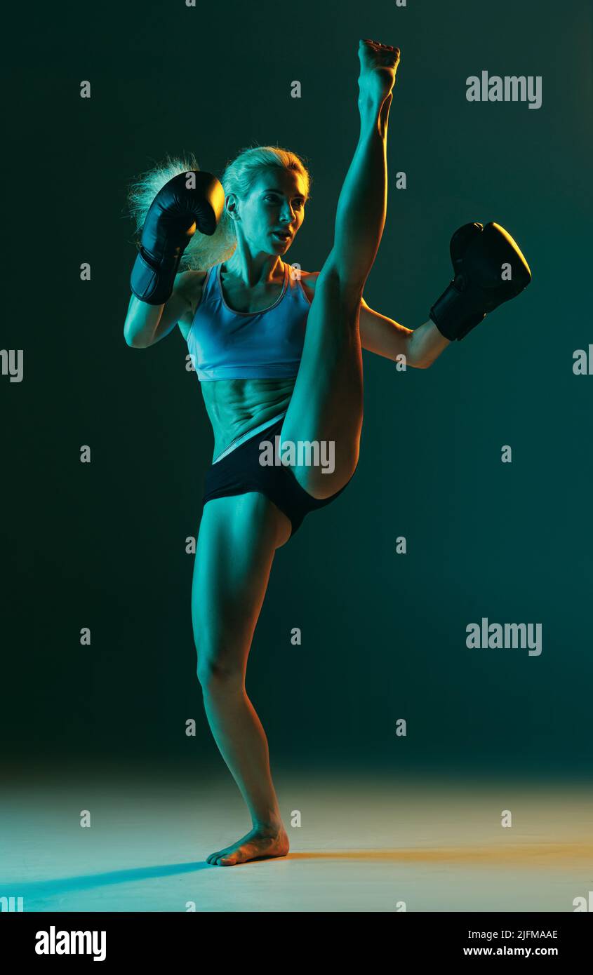 One young woman, female professional kickboxer in sports uniform and ...