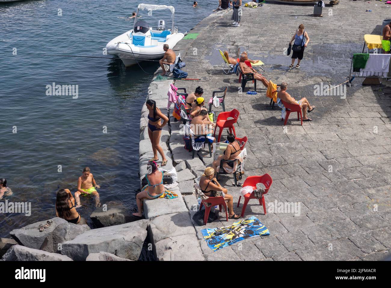 sunbathing locals on the rocks in Naples Stock Photo - Alamy