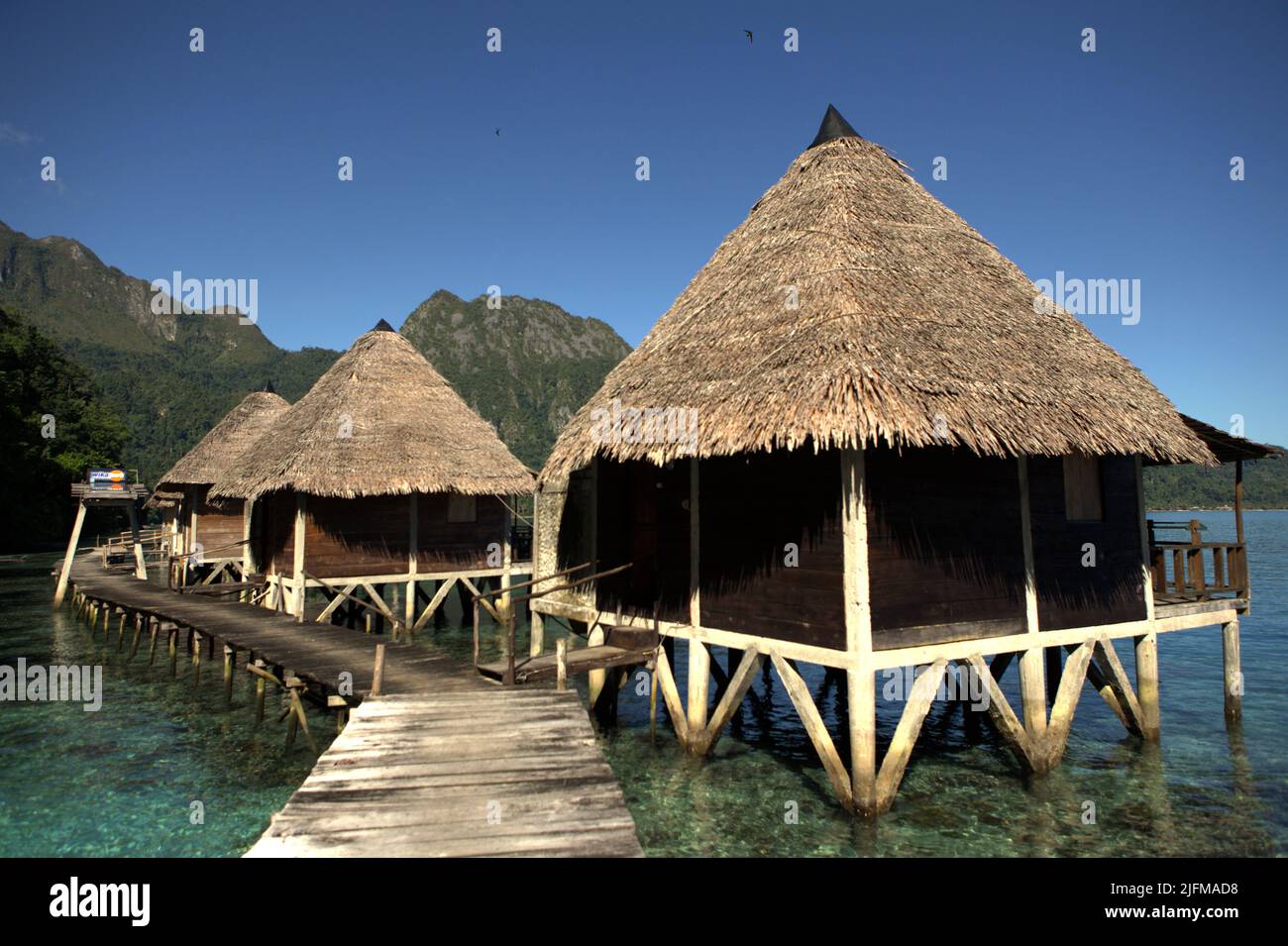 Wooden cottages above sea water at Ora Eco-Resort in Saleman village ...