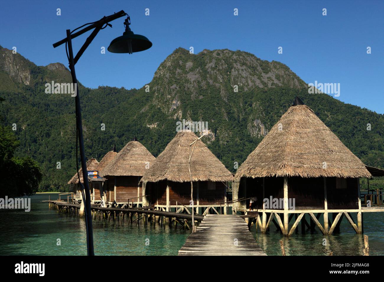 Wooden cottages above sea water at Ora Eco-Resort in Saleman village ...