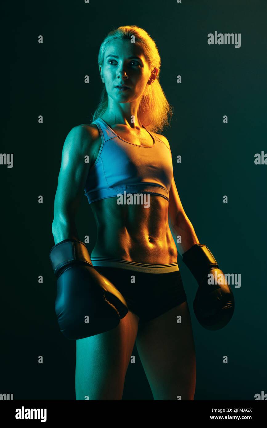 One young woman, female professional kickboxer in sports uniform and ...