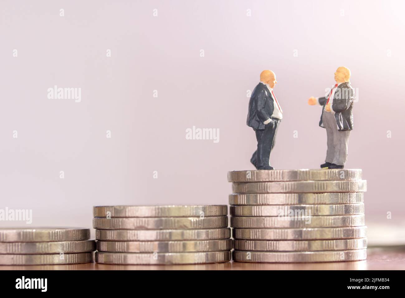 Miniature people : Businessman figures standing on the coin with ...