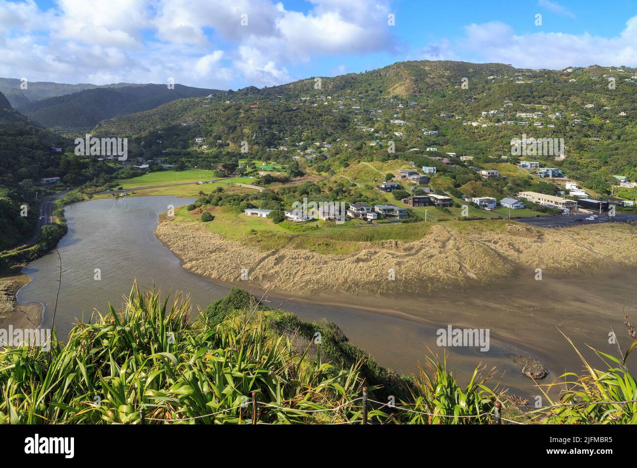 The small coastal town of Piha, New Zealand, seen from a viewpoint high ...