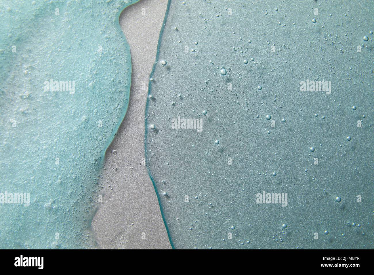 Blue cream liquid gel serum on silver texture, makeup and cosmetics background, skincare or hair ...