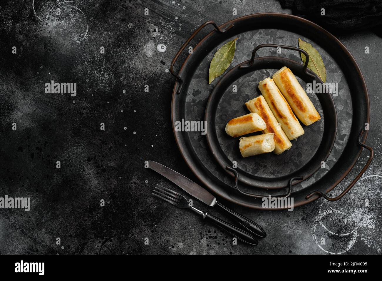 Fried georgian crepes stuffed with suluguni on black dark stone table ...