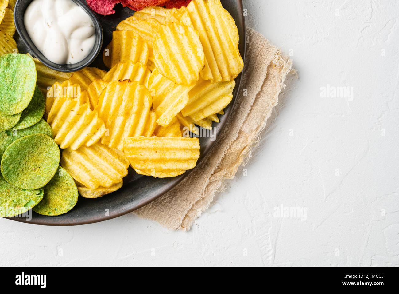 Crispy potato chips on white stone table background, top view flat lay ...