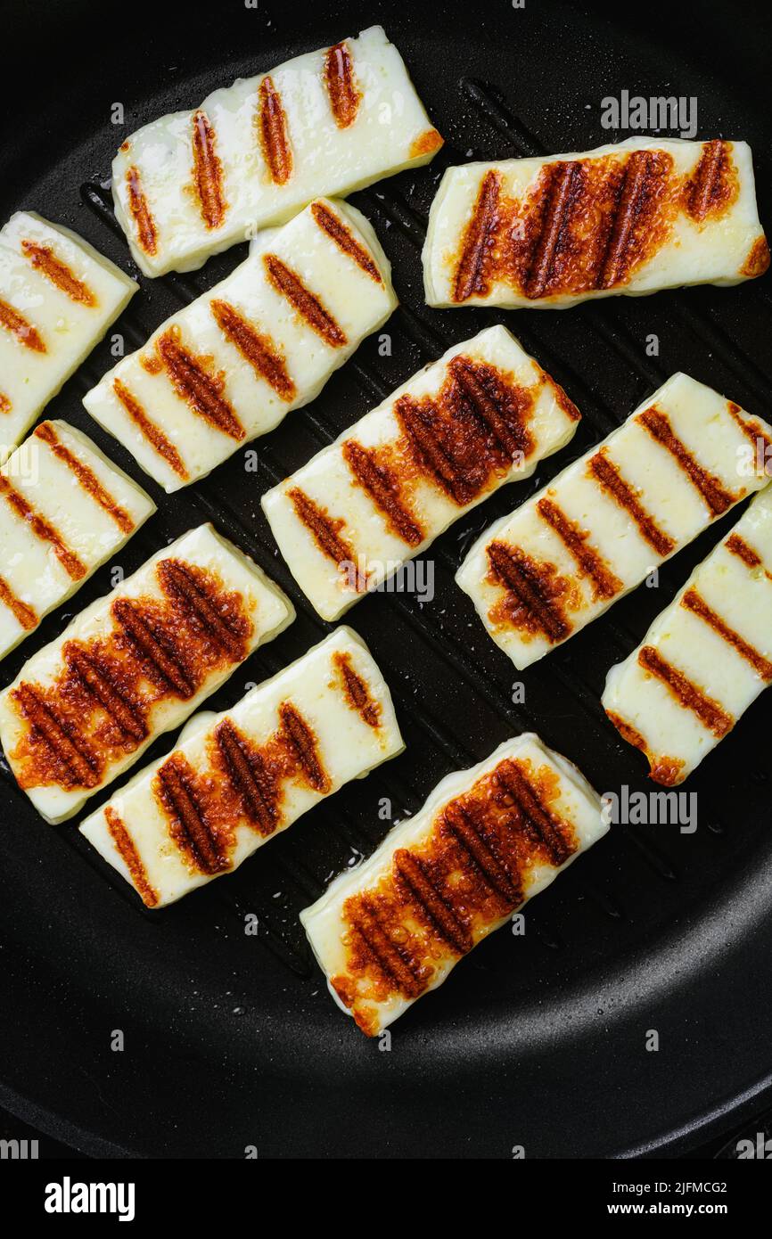 Grilling Halloumi Cheese, on old dark rustic table background, top view ...