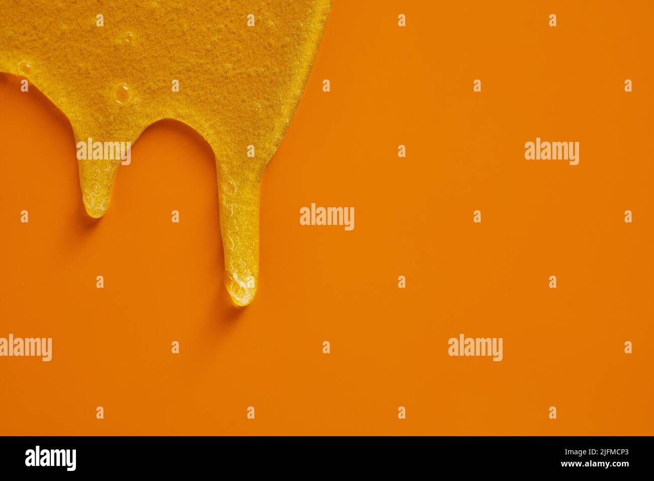 Cream liquid gel serum flows down on yellow texture, makeup and ...