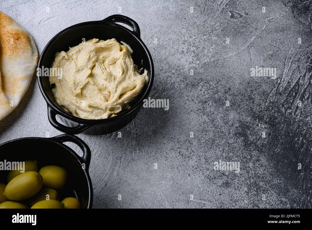 Bowl of tasty fresh hummus set, on gray stone table background, with ...
