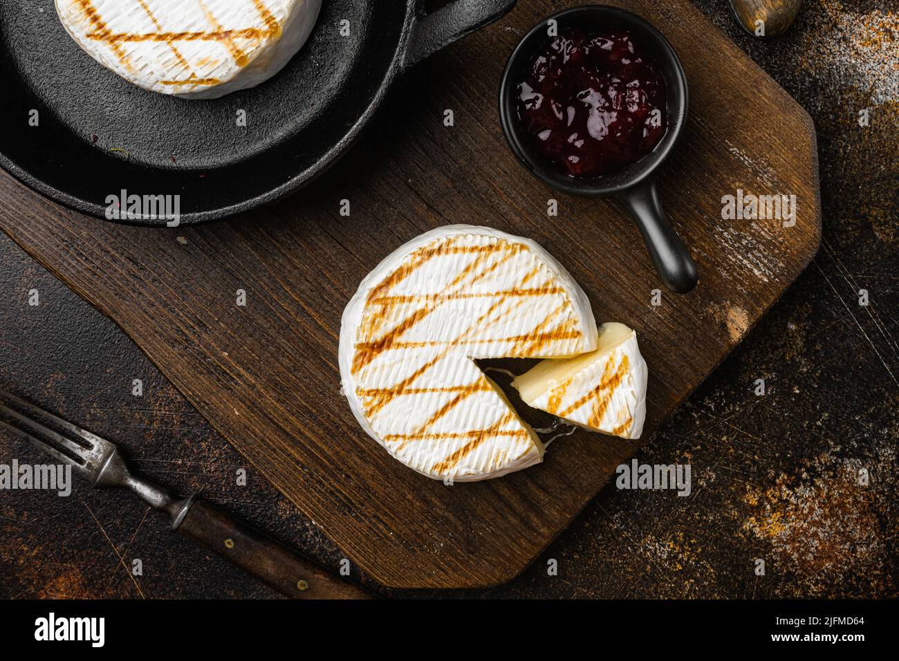 Grilled camembert or brie cheese on old dark rustic table background ...