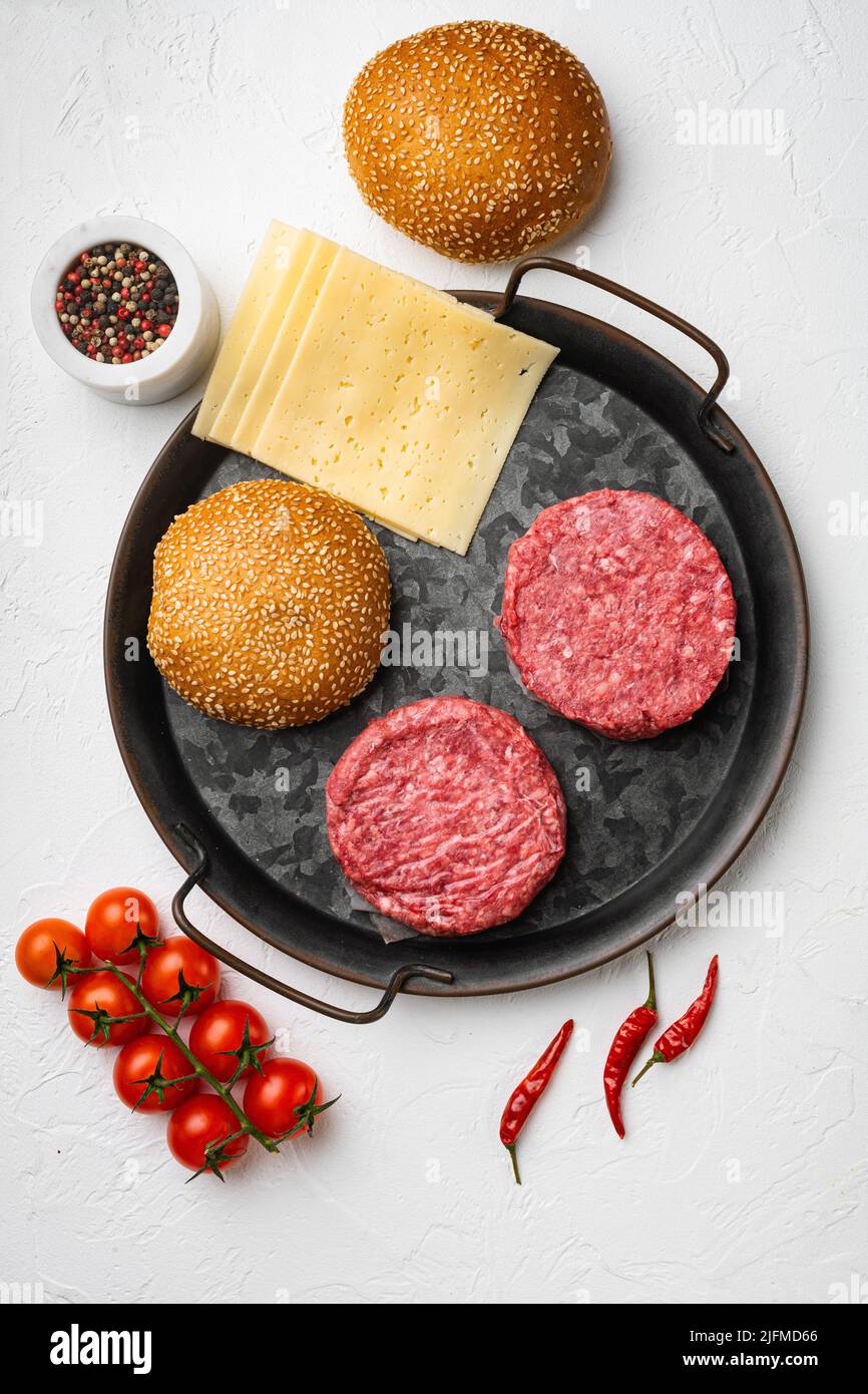 Raw steak cutlets with mince beef meat and rosemary on white stone ...