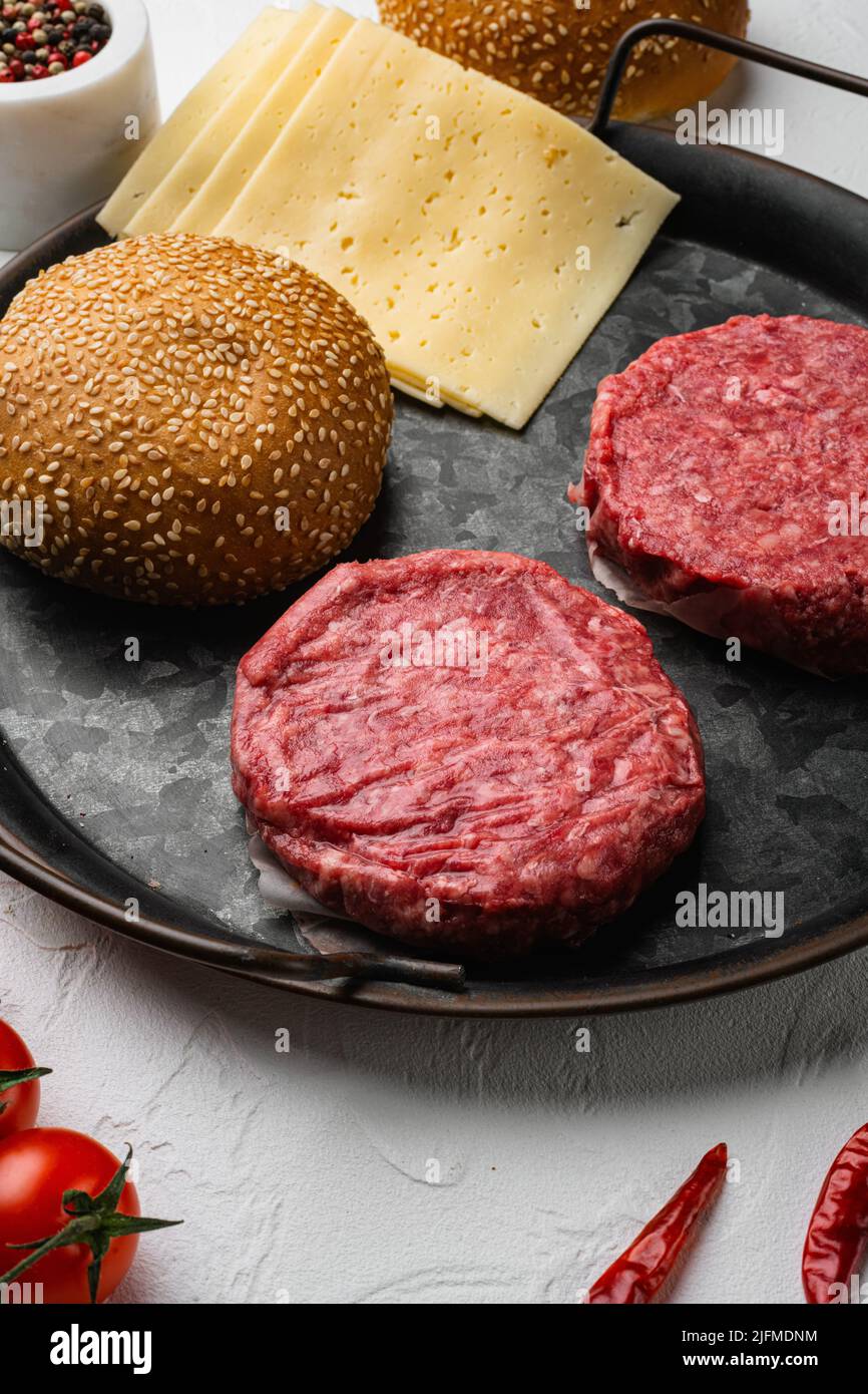 Raw BBQ Beef Burger Cutlets on white stone table background Stock Photo ...