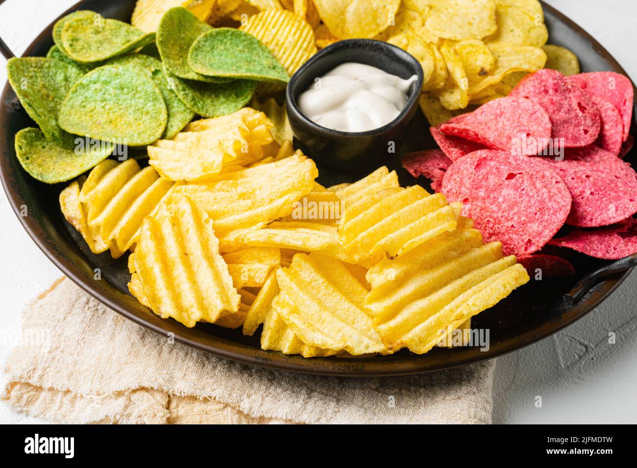 Set potato chips on white stone table background Stock Photo - Alamy