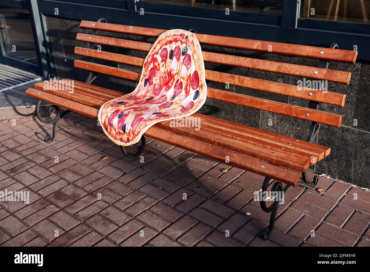 Bench with big pizza on the street of Kiev Stock Photo - Alamy