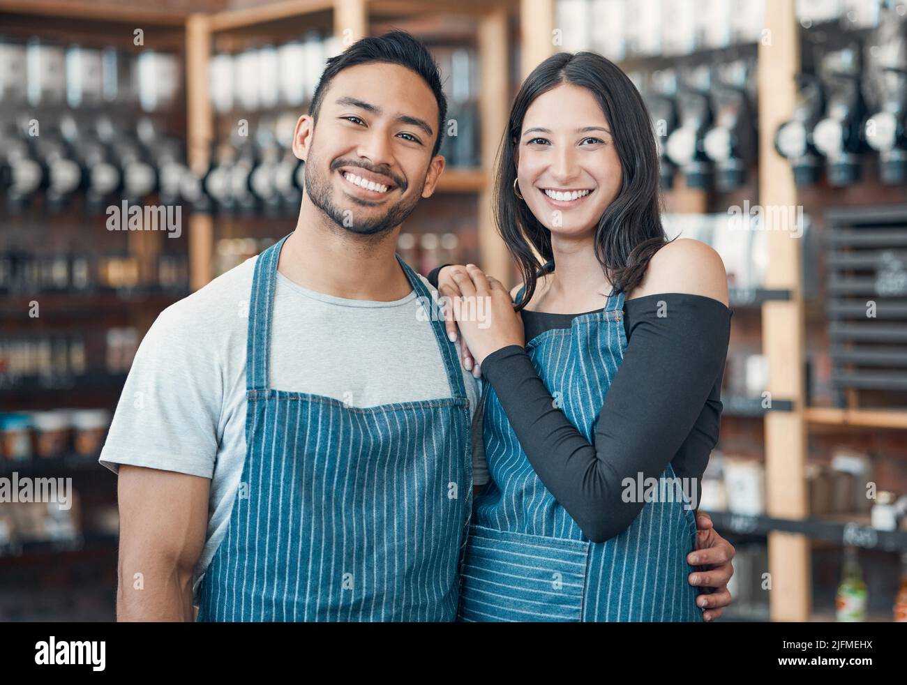 Portrait of a happy young hispanic man and woman working in a store or ...