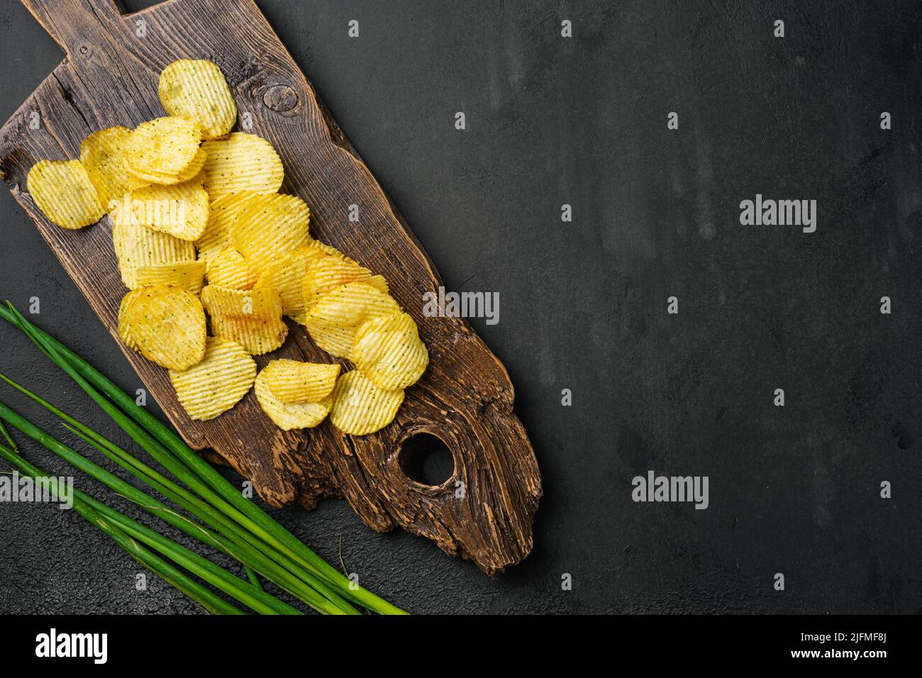 Wavy Ranch Flavored Potato Chips on black dark stone table background ...