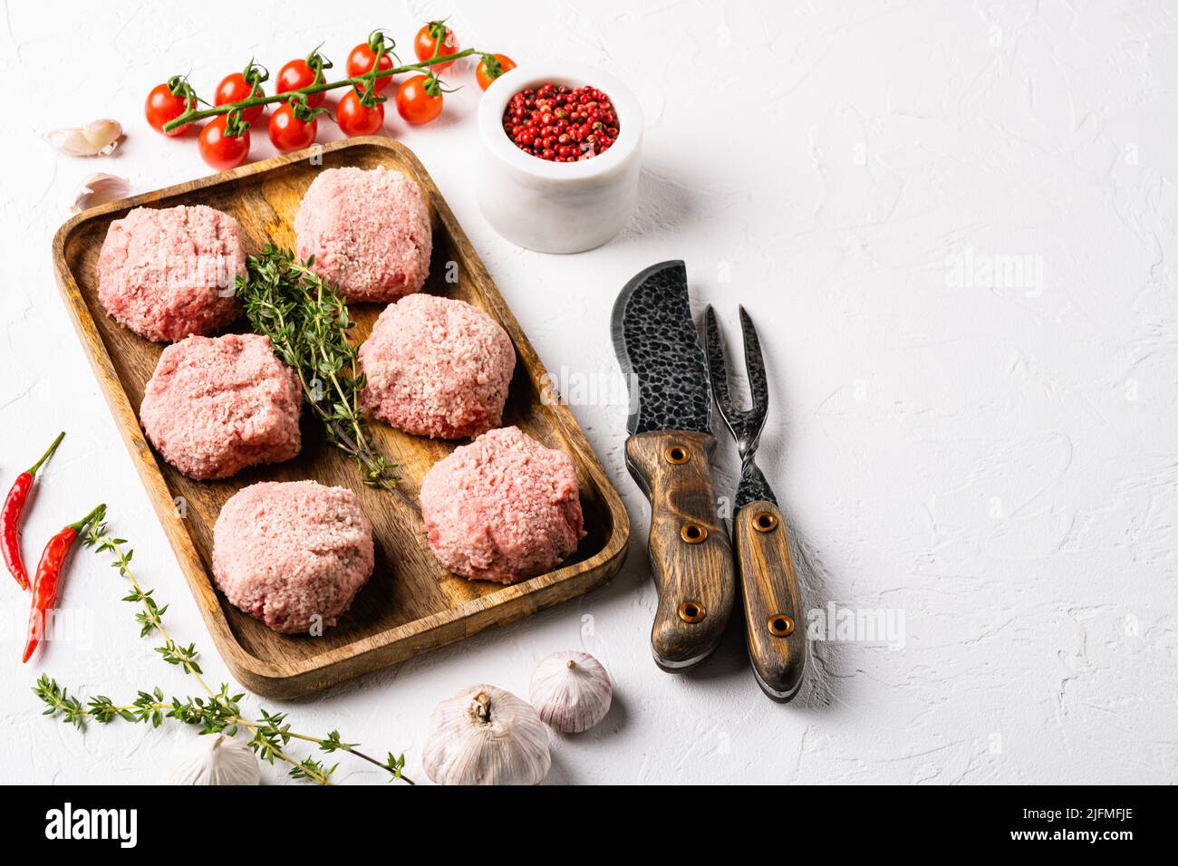 Raw burgers cutlets from organic meat, on white stone table background ...