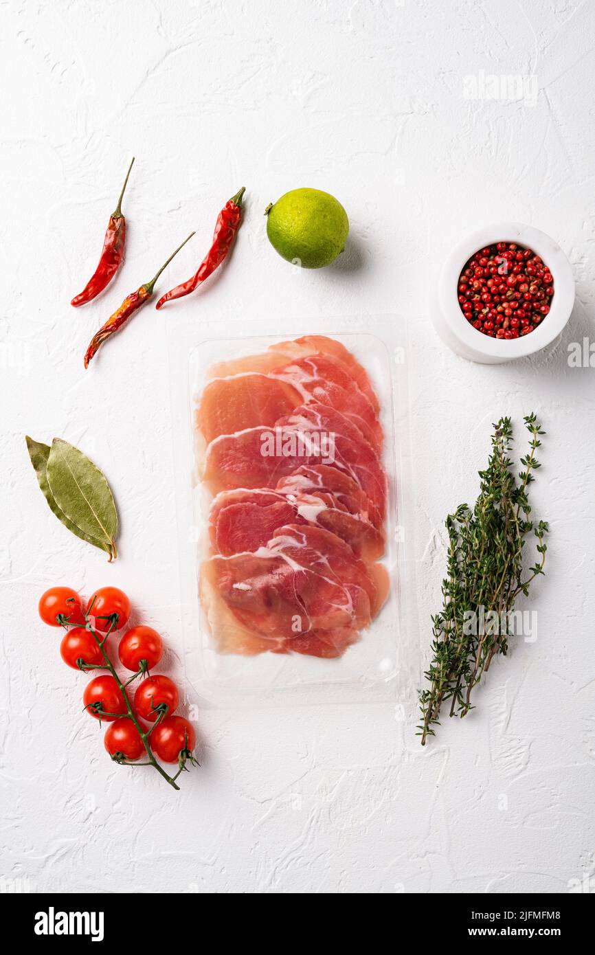 Vacuum packed serrano ham, on white stone table background, top view ...
