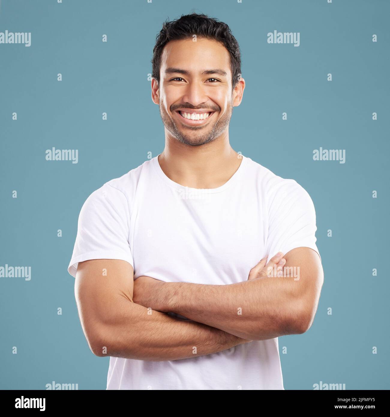Handsome young mixed race man with his arms crossed while standing in ...