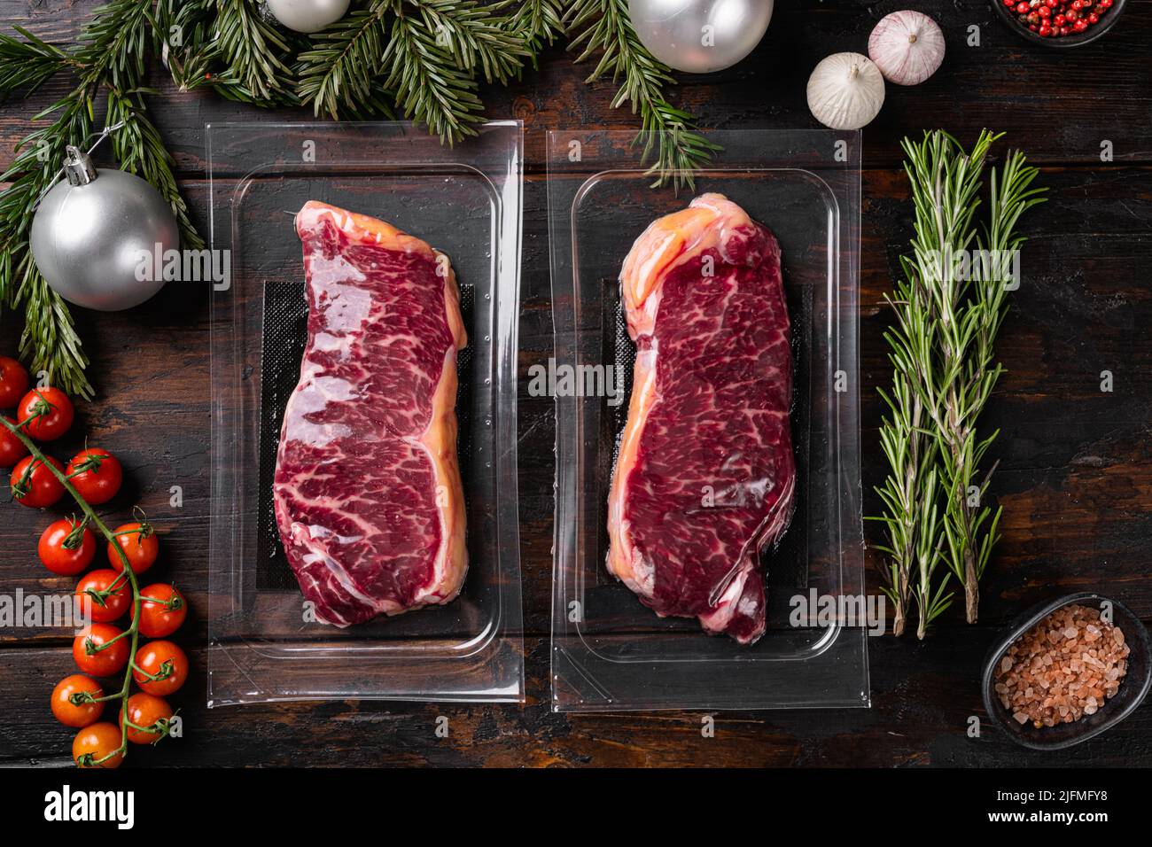 Vacuum packed organic raw beef, on old dark wooden table background ...