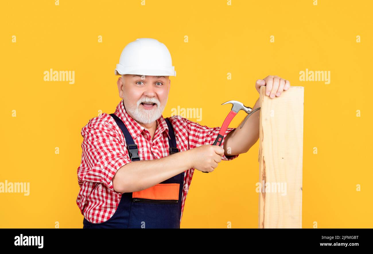 cheerful aged man woodworker in helmet on yellow background Stock Photo ...