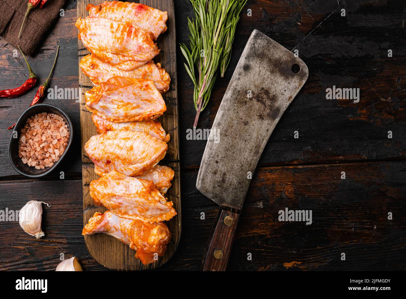 Raw marinated chicken wings with spices, on old dark wooden table ...