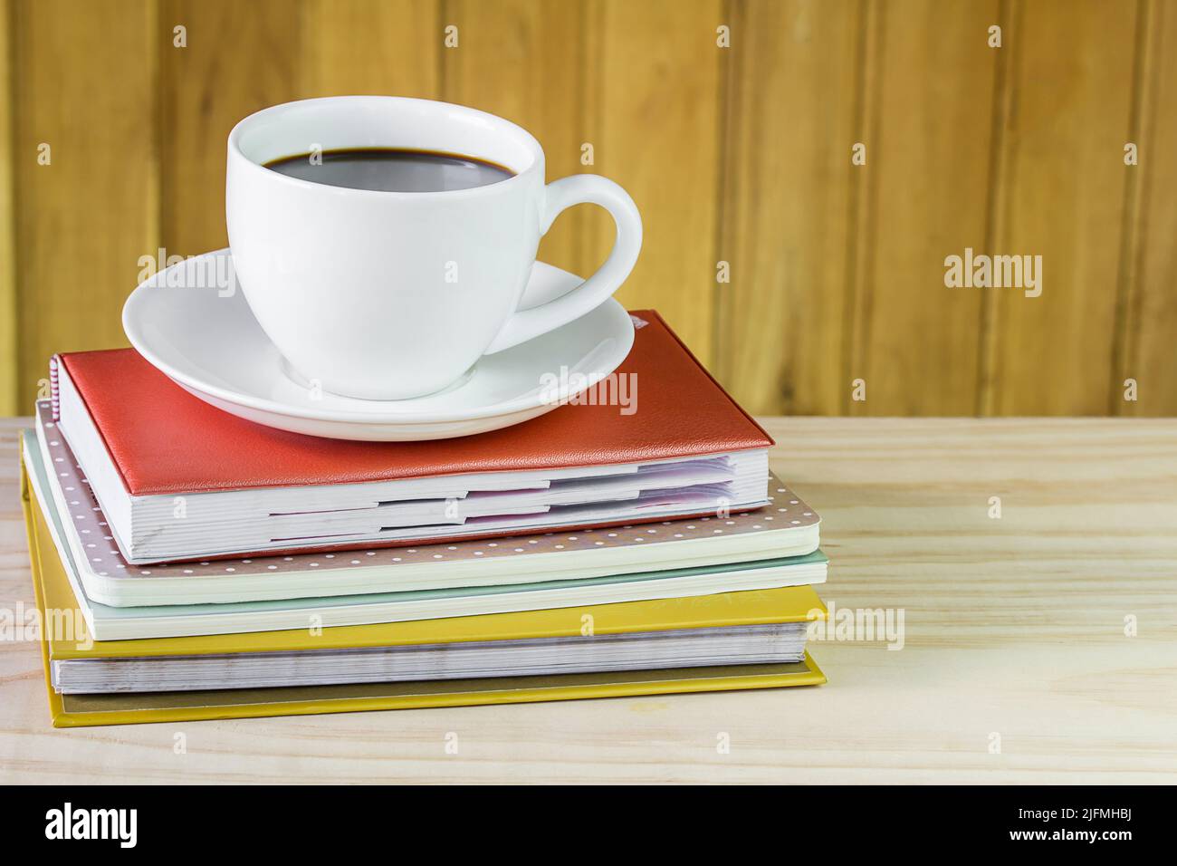 Cup of coffee and note book on wooden table background Stock Photo - Alamy