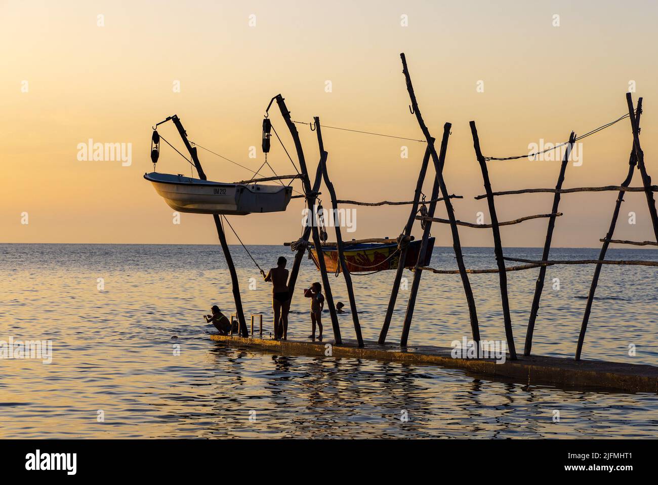 Boats hanging from traditional wooden cranes at sunset, Savudrija ...