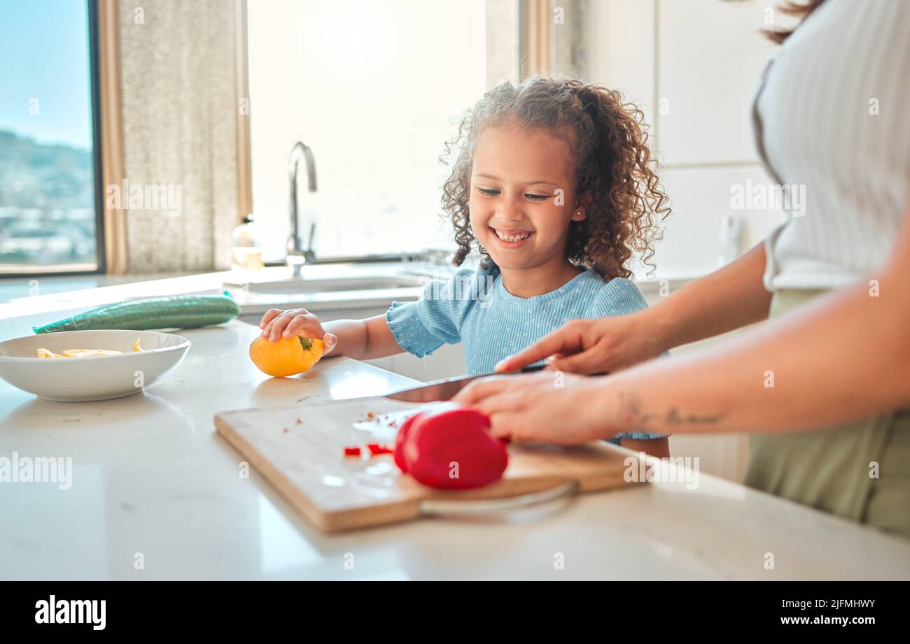 Mother and daughter cooking together. Little girl preparing food with ...