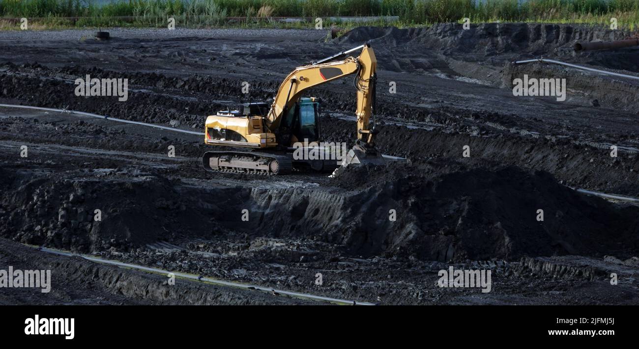 Kiev, Ukraine March 18, 2020: Working excavator digging black soil soil ...