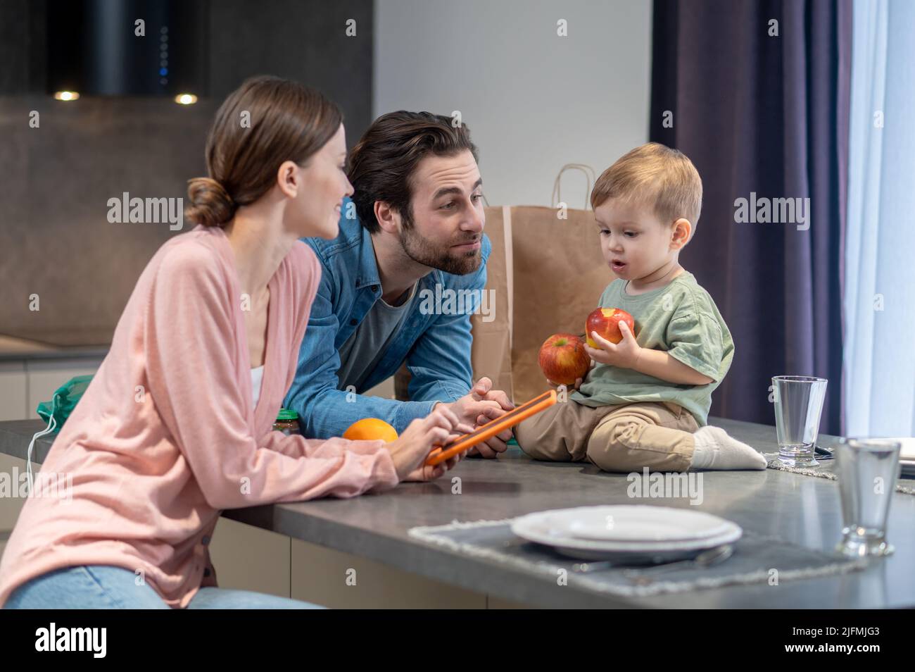 Cute young family with a small kid in the kitchen Stock Photo - Alamy