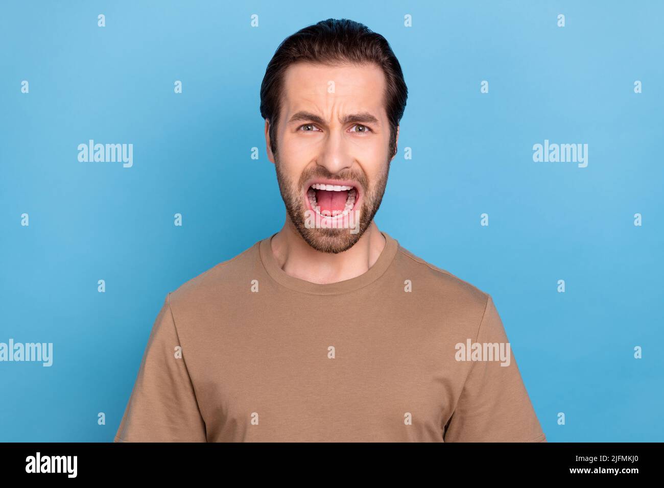 Photo of impressed angry young man wear casual brown outfit shouting ...