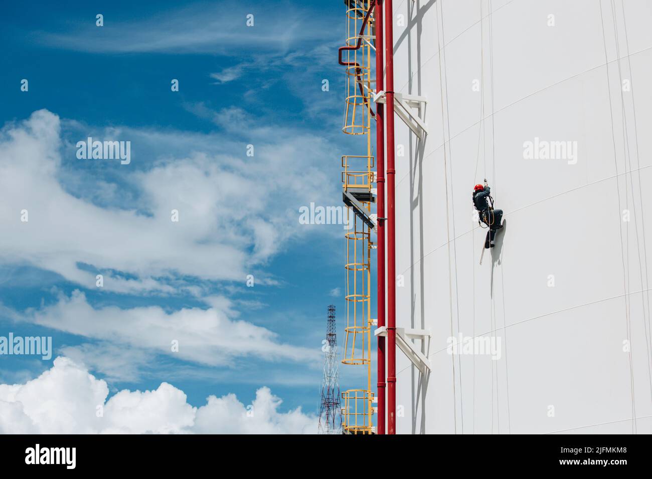 Male workers control swing rope down height tank rope access inspection ...