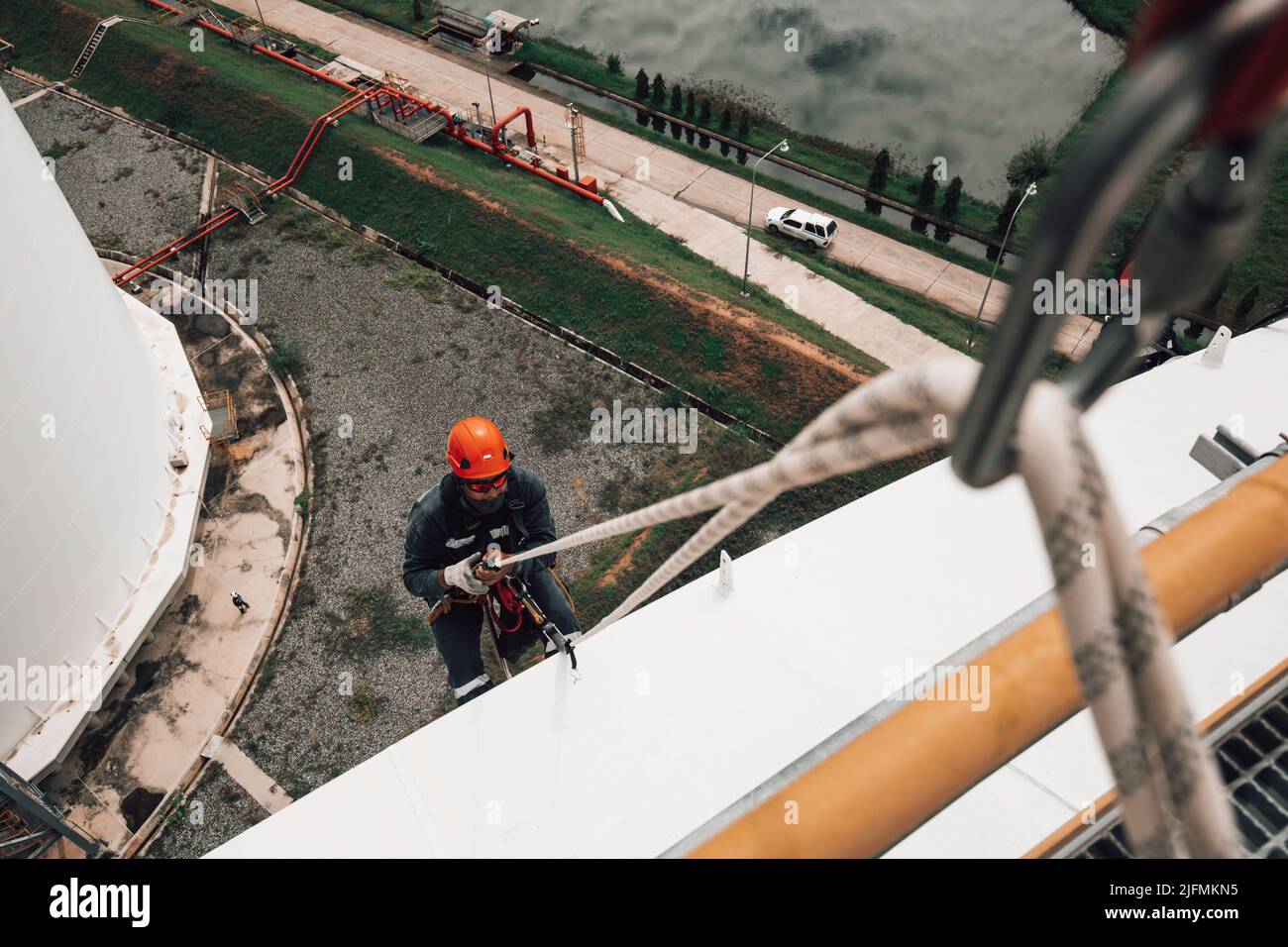 Top view Male worker down height tank shell plate rope ladder access ...