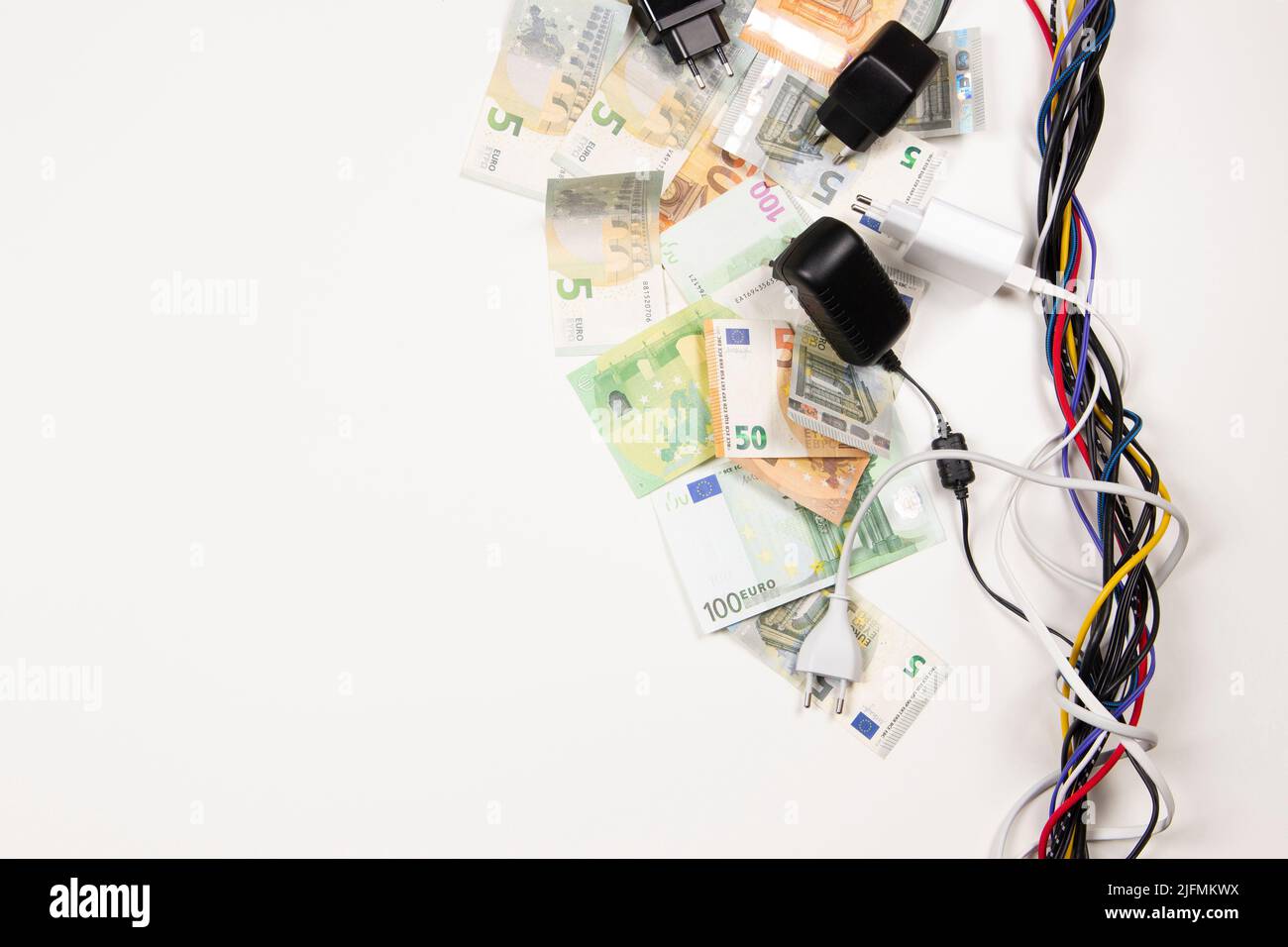 Electric power plugs with cash Euro banknotes on white background ...