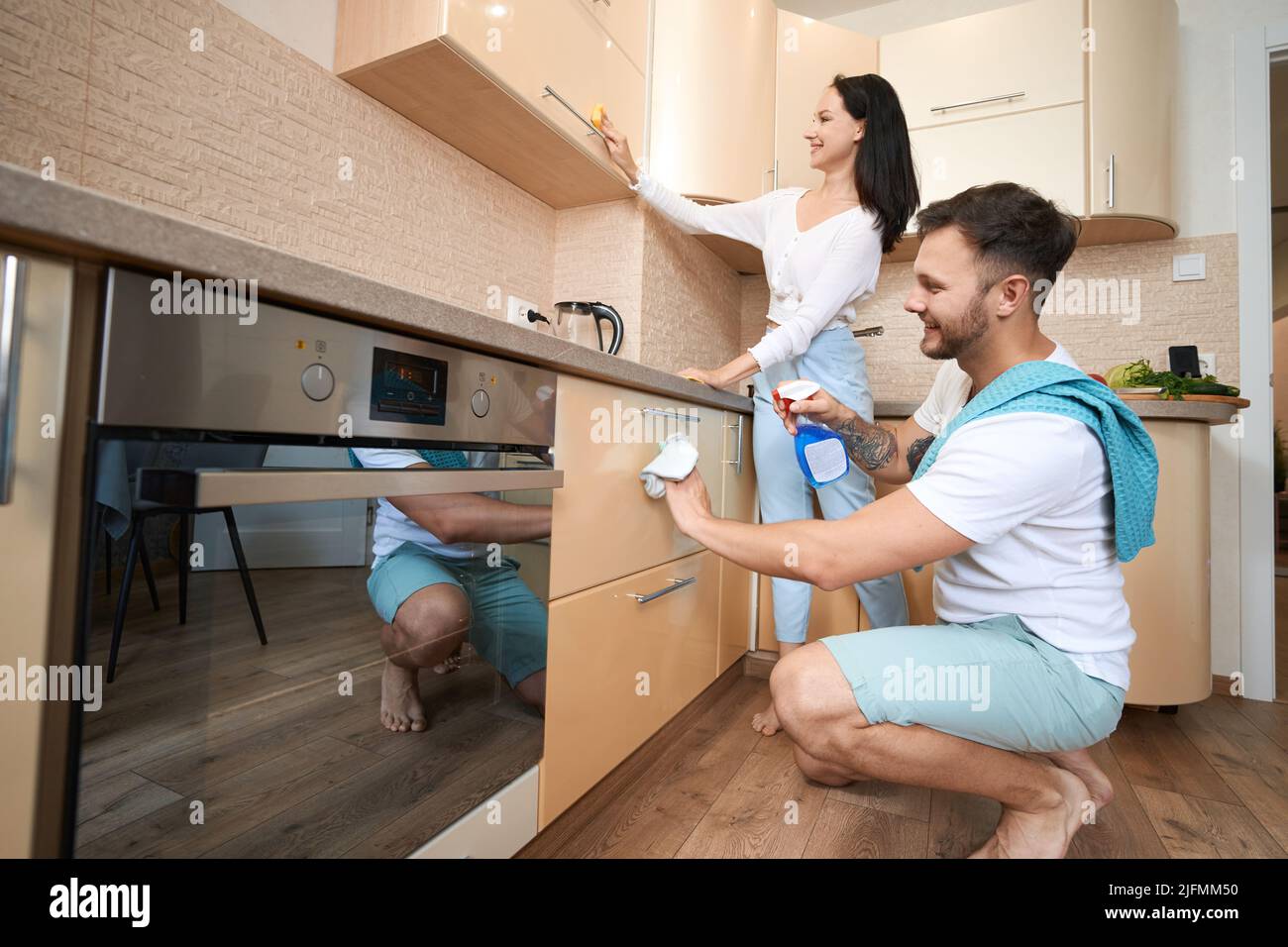Married couple tidying up their kitchen together Stock Photo - Alamy