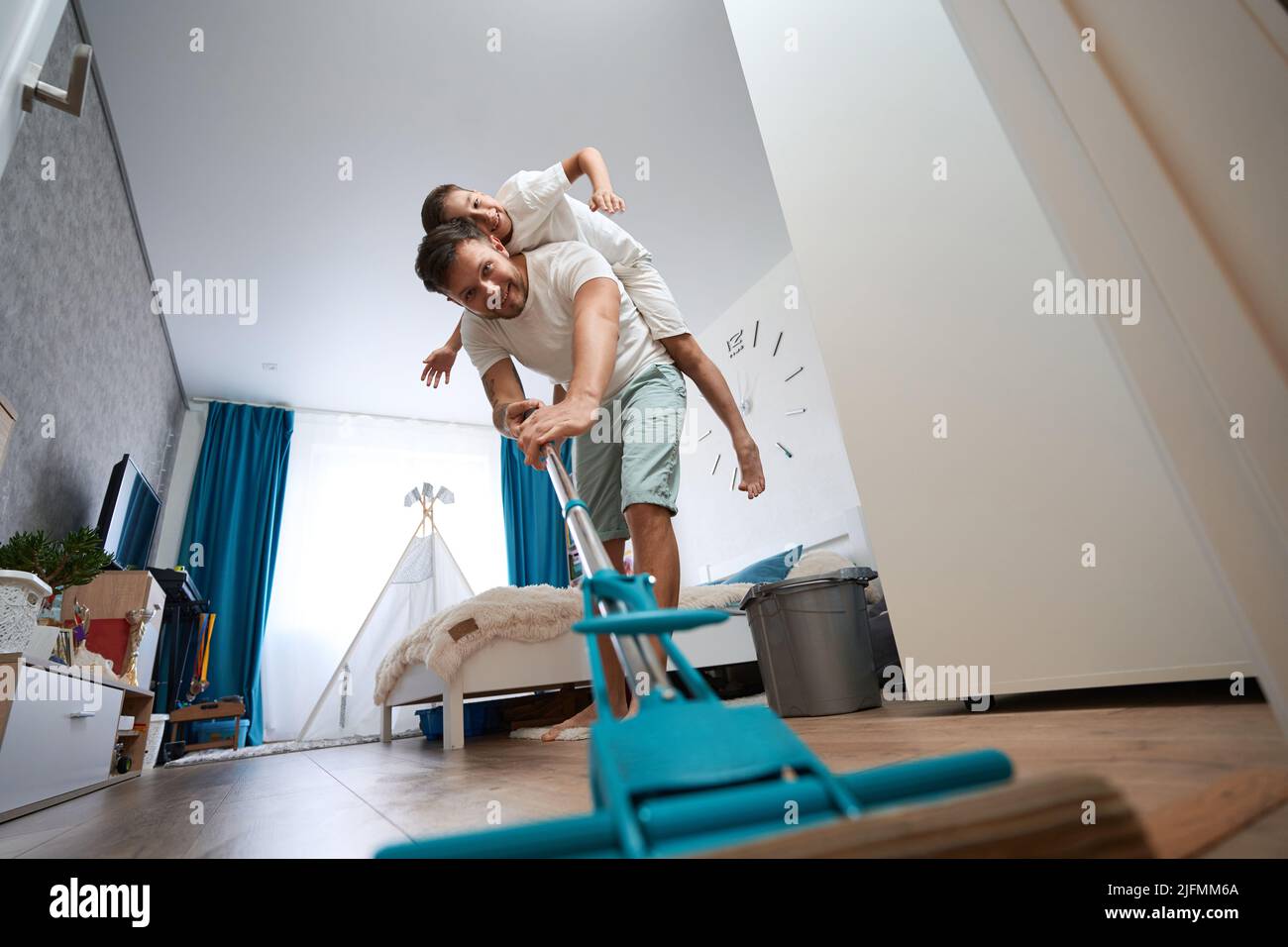 Kid fooling around on father back during floor washing Stock Photo - Alamy
