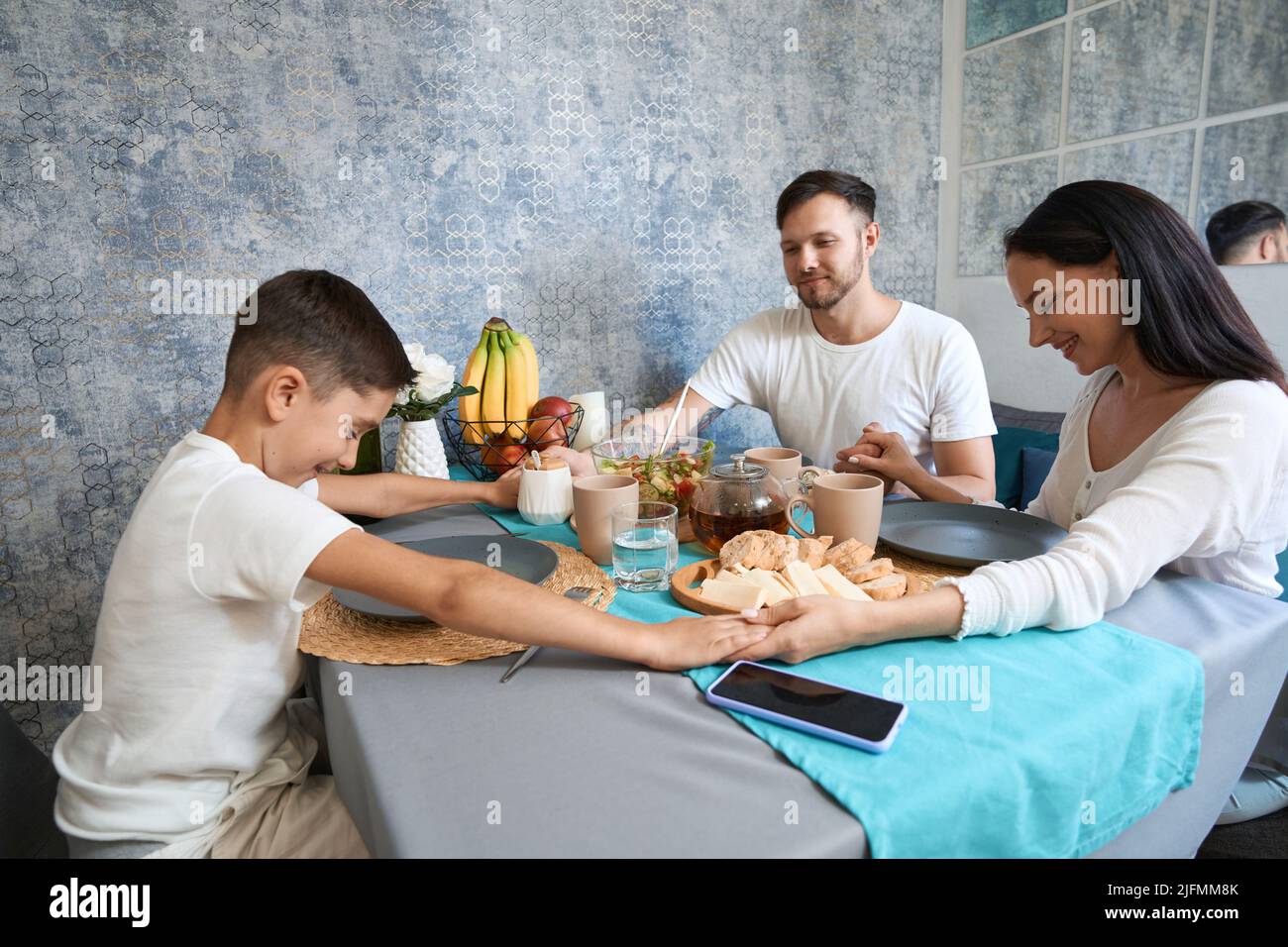 Family members praying before meal at dinner table Stock Photo - Alamy