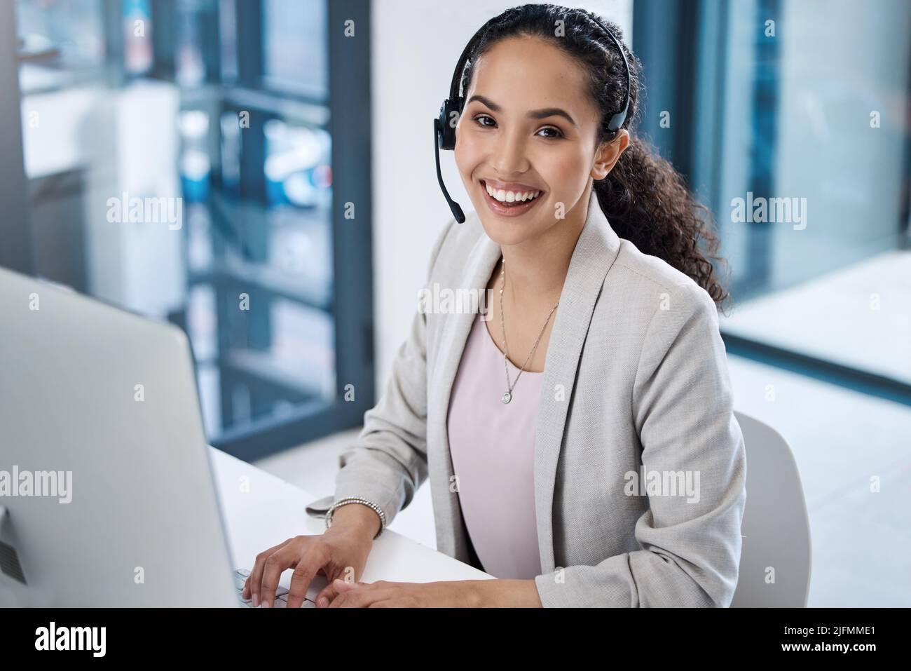 Young happy mixed race female call center agent using a desktop ...