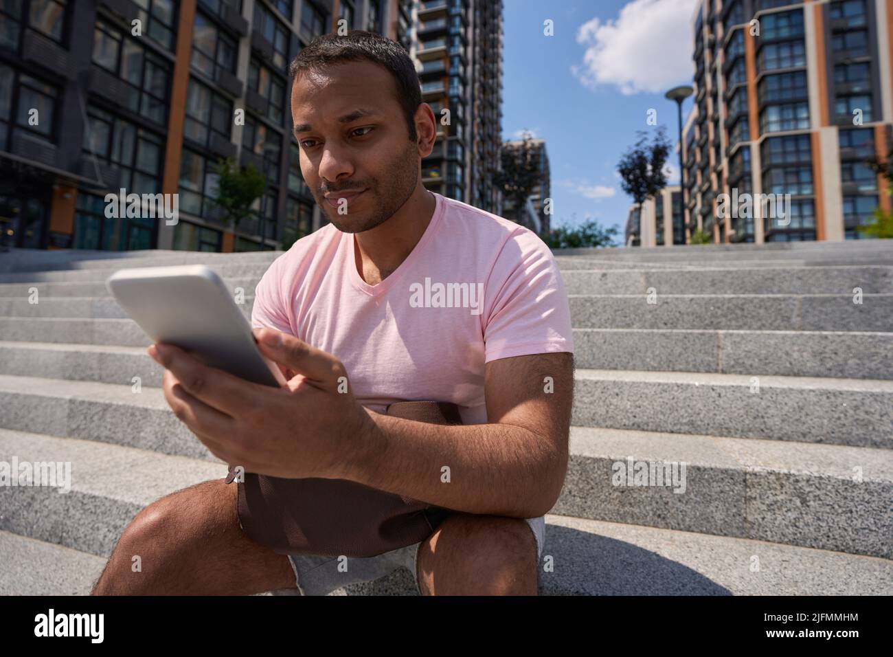 Concentrated man staring at cell phone in his hands Stock Photo - Alamy