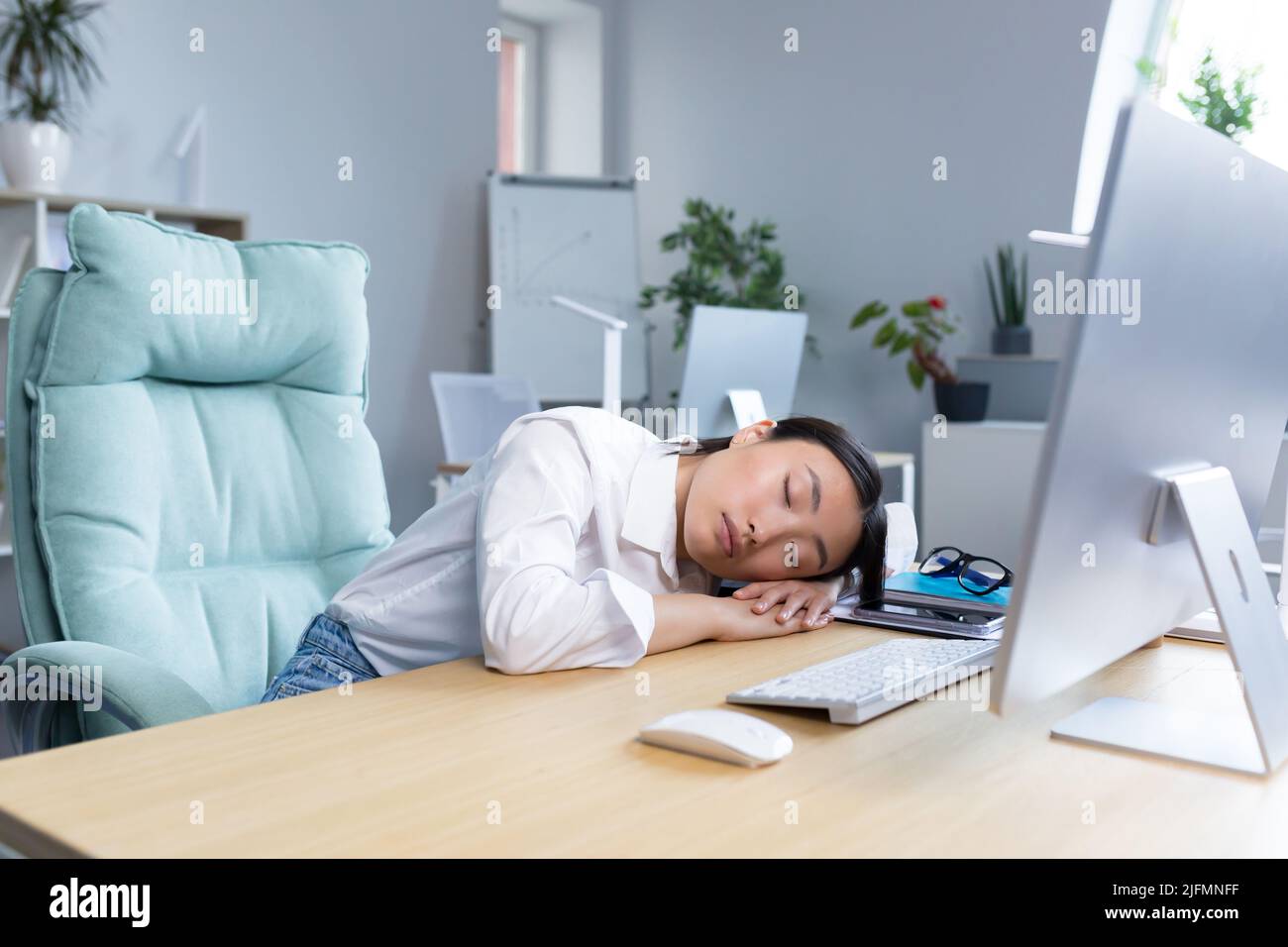 Woman office worker tired Asian sleeps on the desk, overtired sleeps in ...