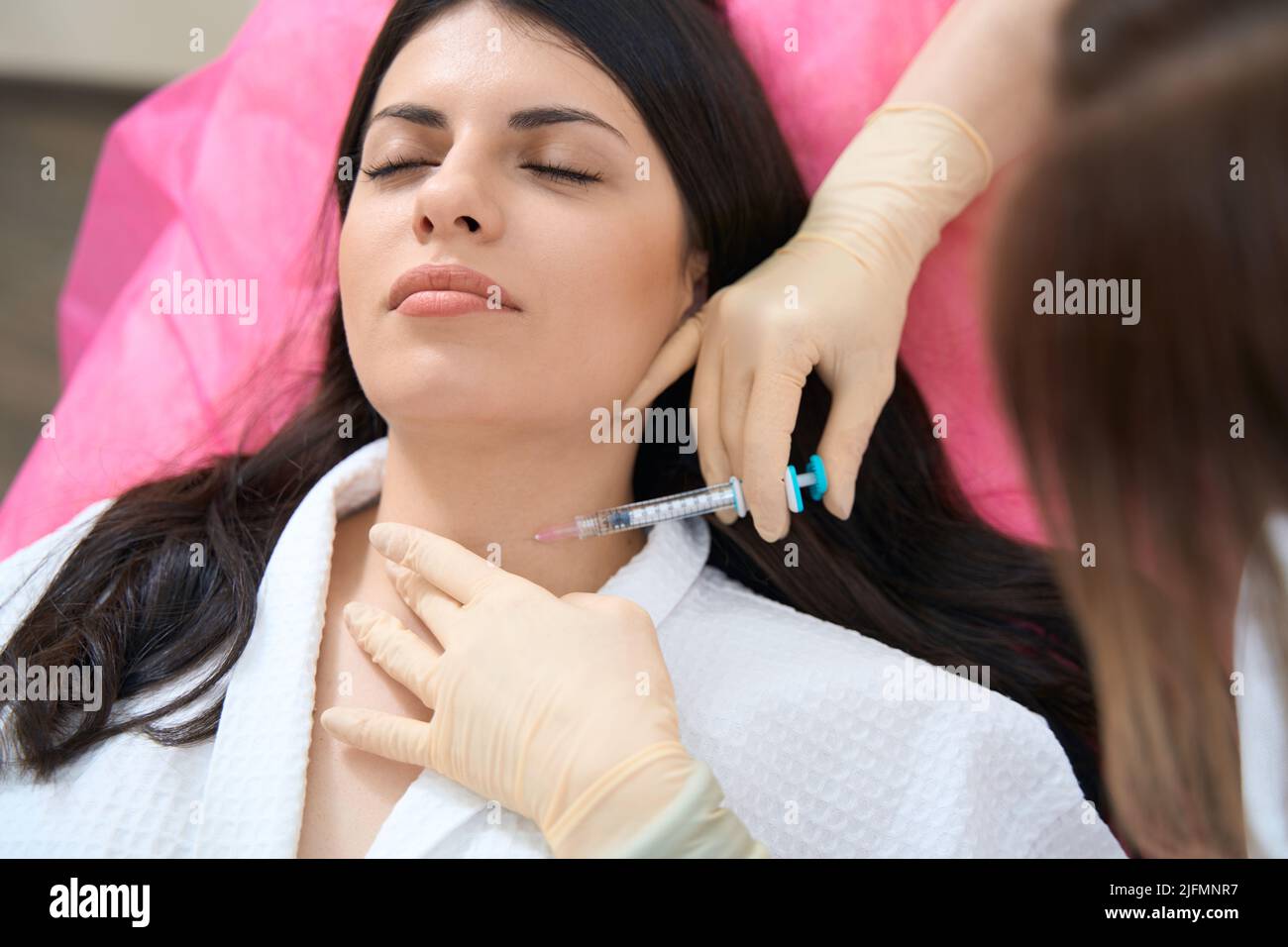 Doctor makes injections in patient neck to rejuvenate and moisturize ...