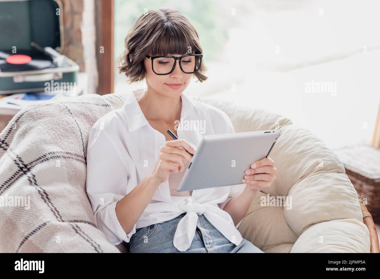 Photo of minded young focused woman hold hand tablet pen work remote indoors inside house home ...